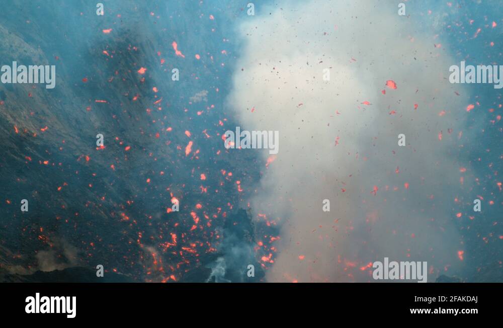 CLOSE UP: Glowing particles of lava fall back to the ground after ...