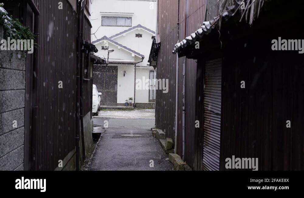 Alleyway in a Japanese city with fresh falling snow. Traditional ...