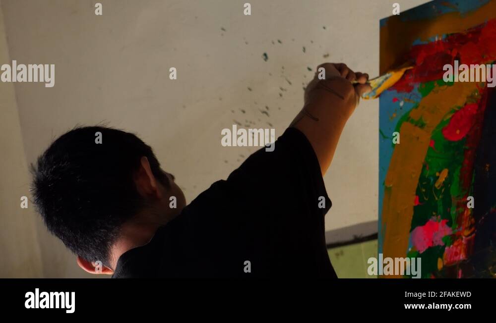 Chinese man painting making art in studio with dramatic lighting Stock ...