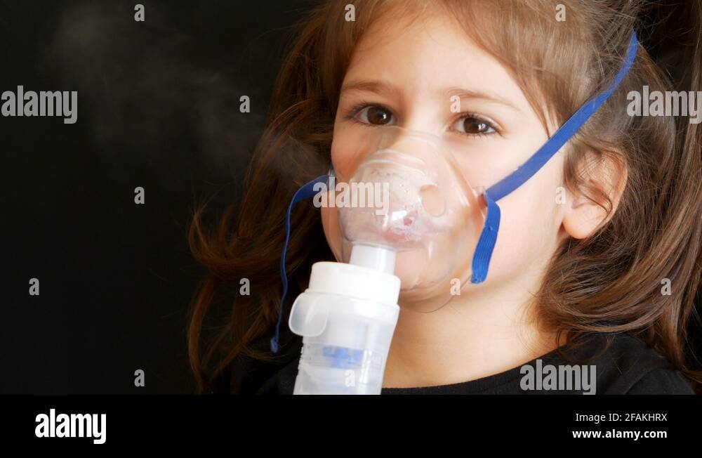 Little girl making inhalation with inhalator mask at home 4K Stock ...