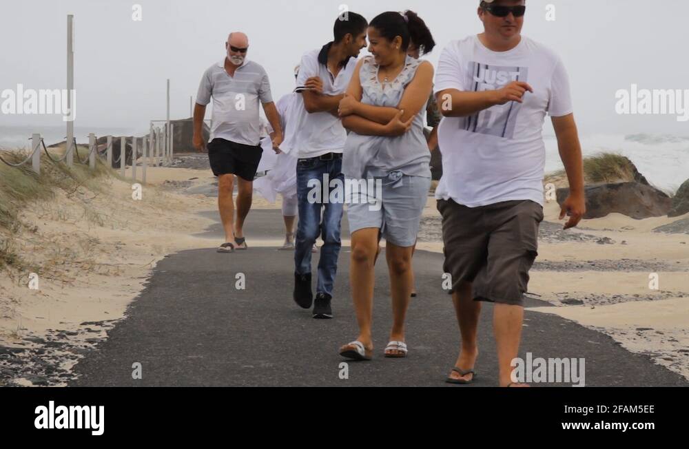 Groups of people coming to look at damage to a beach caused by a Stock ...