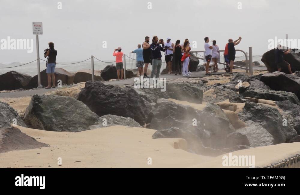 Groups of people coming to look at damage to a beach caused by a Stock ...