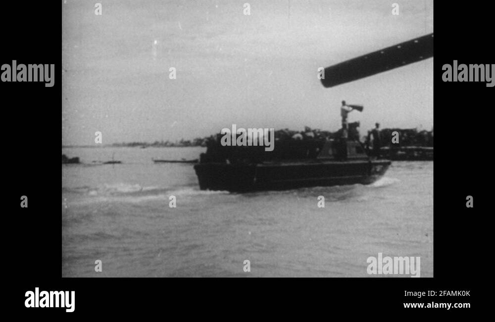 1940s: Soldiers in open top boats approach shore. Text placard ...