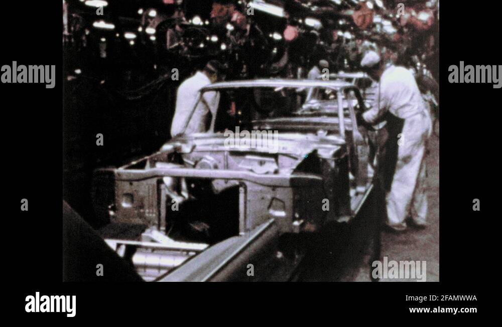 1960s: Workers weld cars on assembly line. Men working on car frame ...