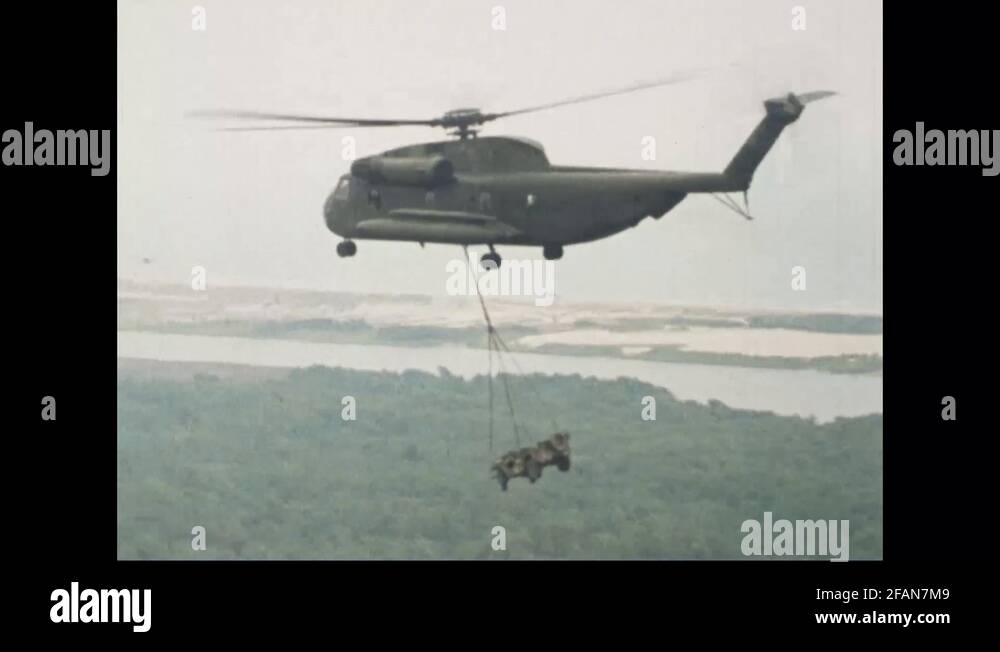 A Marine Corps CH-53D carries a Humvee during external lift exercise ...
