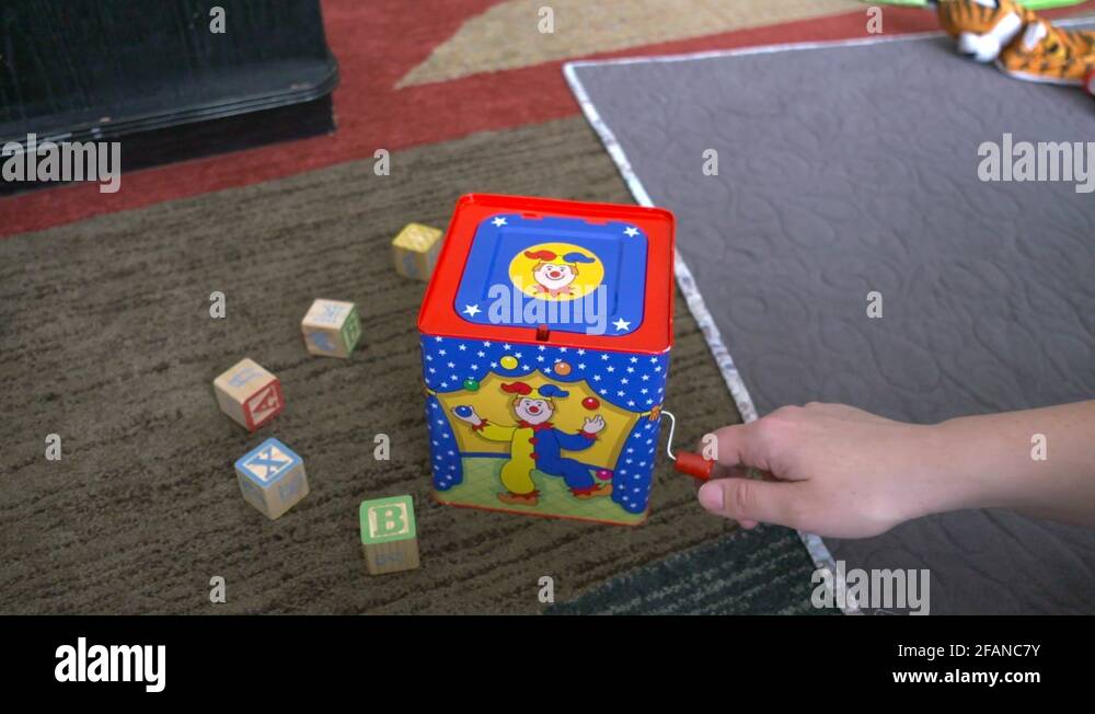 A woman's hand winding a jack-in-the-box toy until it pops up Stock ...