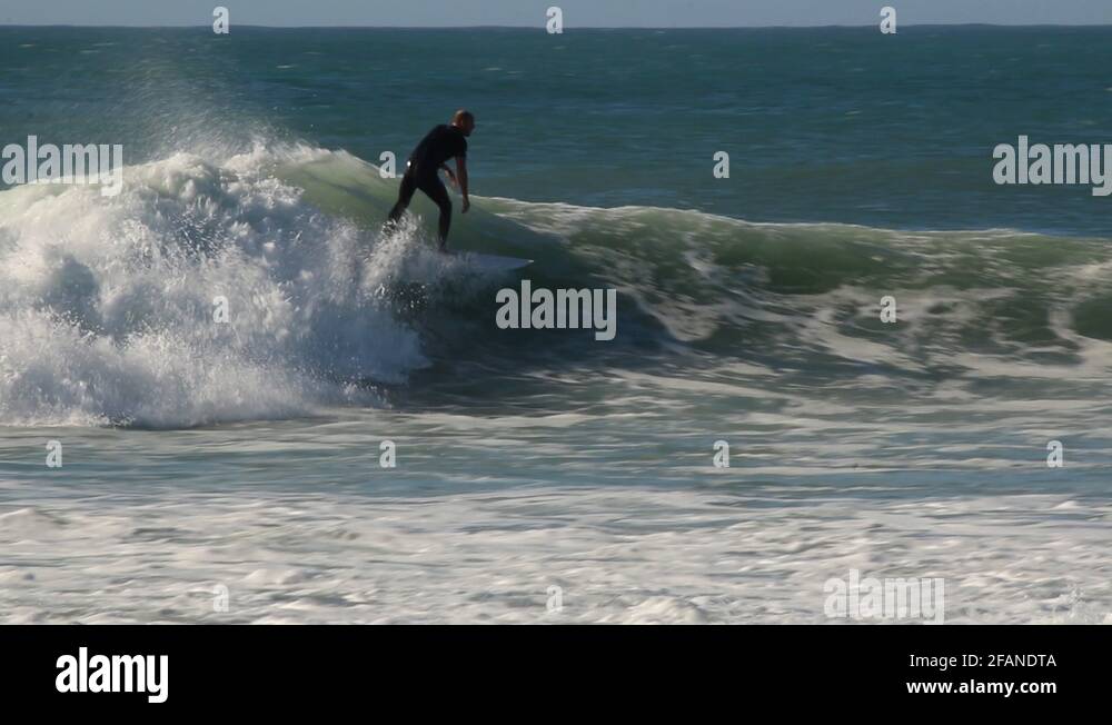 Surfer catching a left hand wave in Taranaki New Zealand wiping out as ...