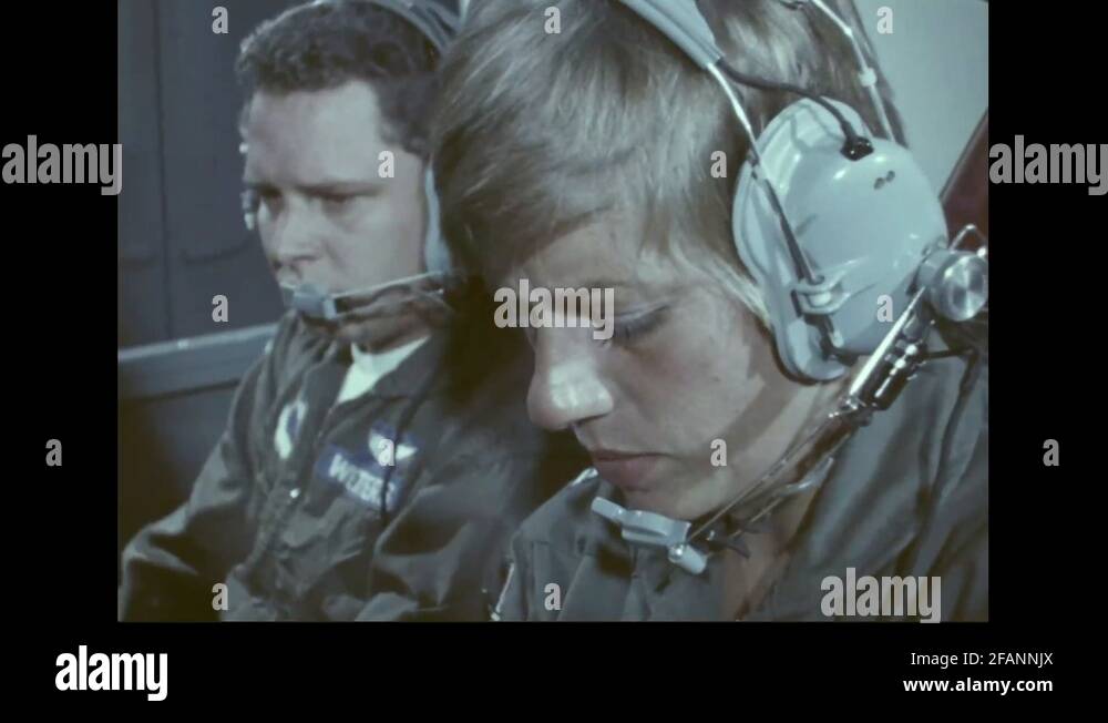 Trainee pilot operates controls in cockpit under guidance of instructor ...