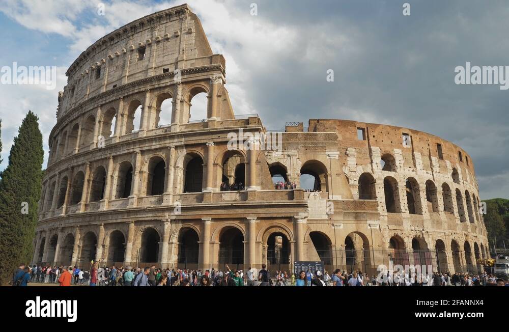 Colosseum front view, tourists walking at the base of great building ...