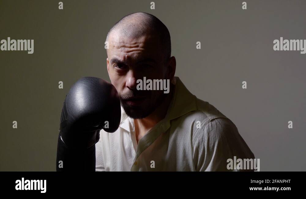 boxer man is moving in white background, holding hands in boxing gloves ...