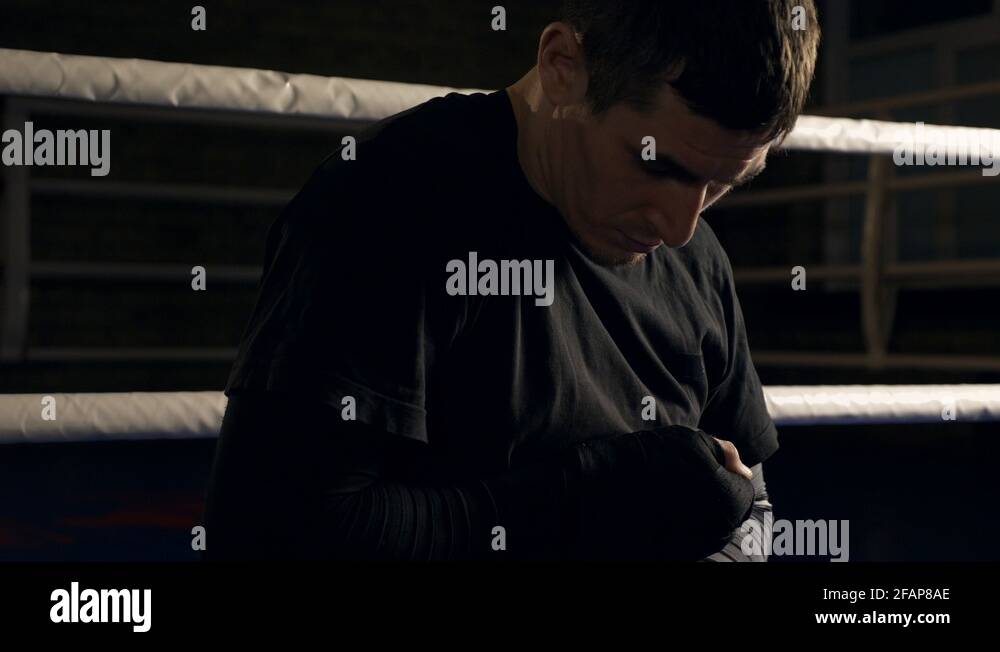 Muay Thai Boxer Putting on Hand Wraps While Sitting on Boxing Ring ...