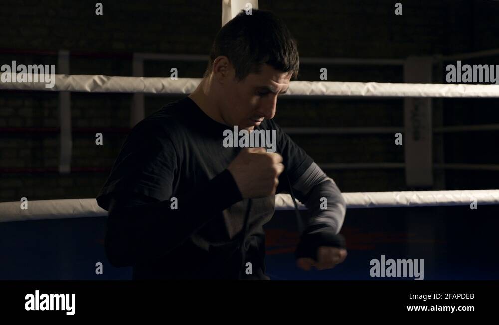 Slow motion Muay Thai Boxer Putting on Hand Wraps While Sitting on ...