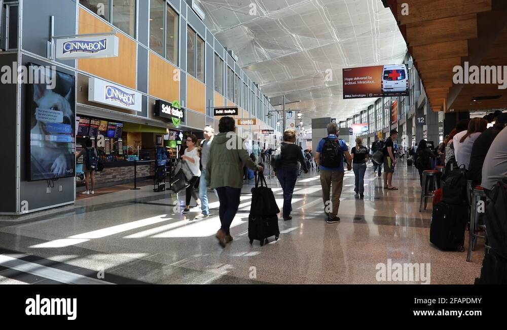 Passengers carrying baggage walk through the Barbara Jordan Terminal at ...
