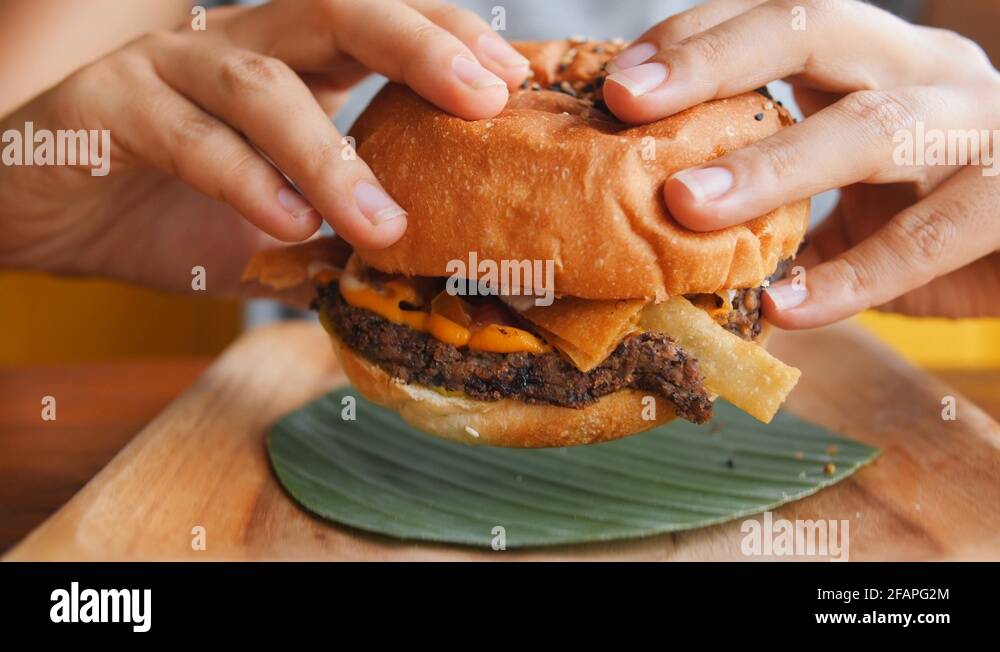 Young Vegan Girl Eating Veggie Burger in Fast Food Restaurant. Woman ...