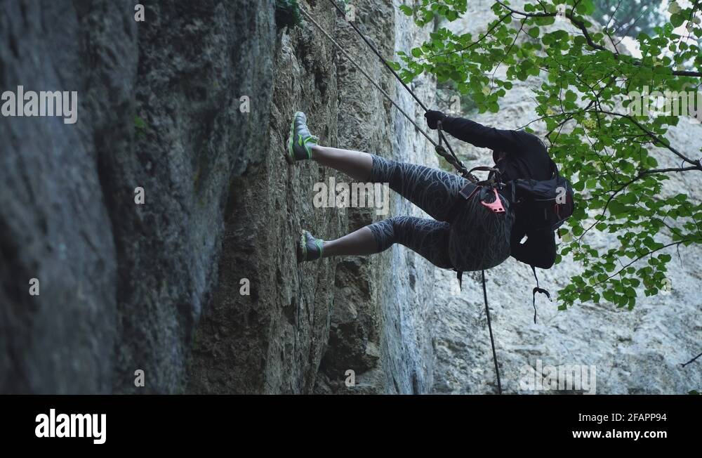close view climber goes down rocky cliff with safety rope Stock Video ...