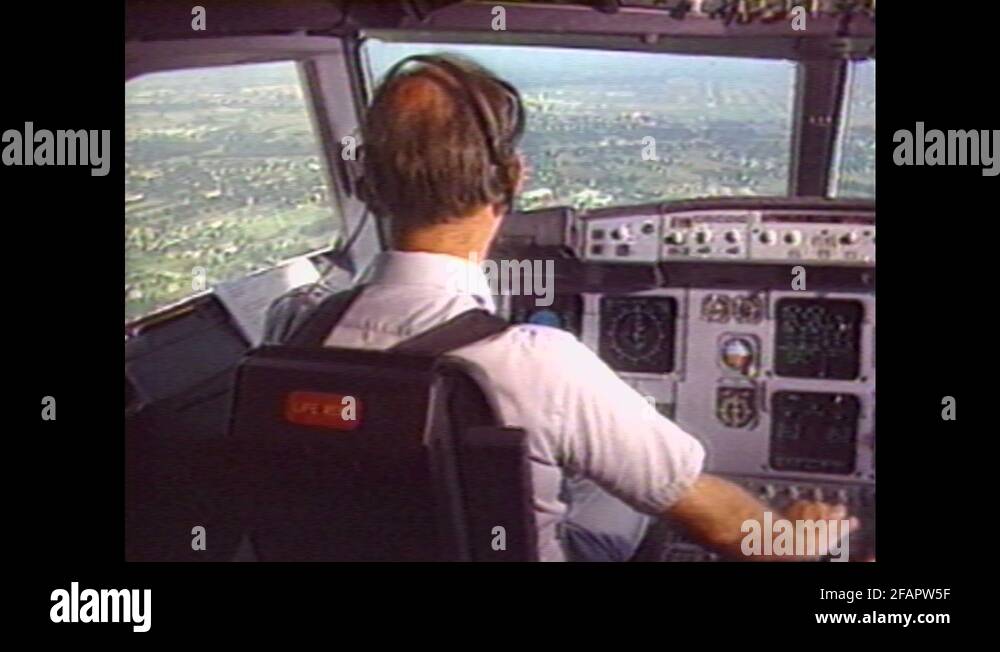 1990s: Pilot in the airplane cockpit in the air. Airplane flies, sky ...