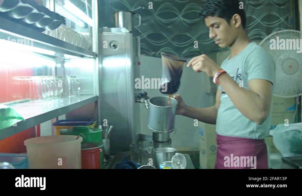 Young malaysian guy making coffee at a shop in Kuala lumpur - side view ...
