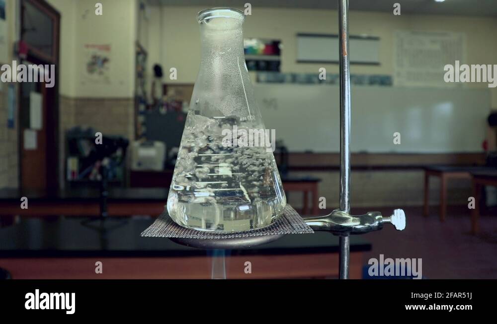 Water boiling in an erlenmeyer flask, heated by bunsen burner in a ...