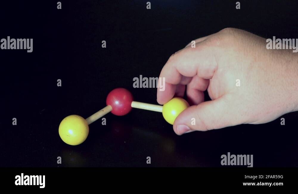 Ball and stick model of water beinged around on a black lab bench Stock ...