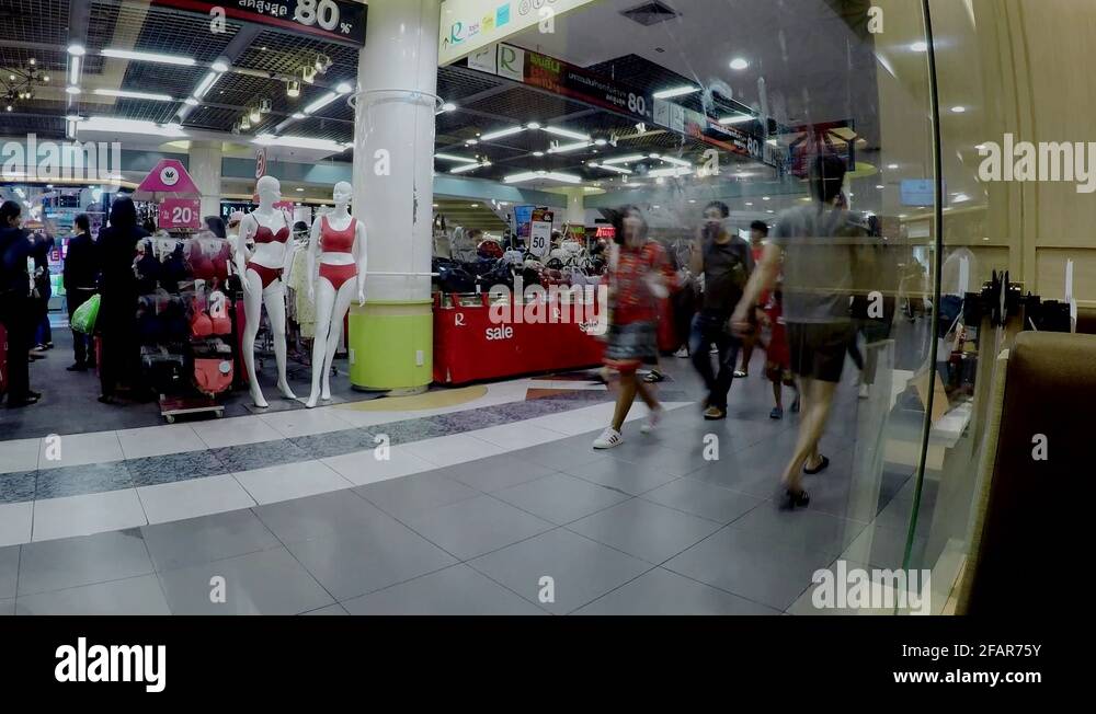 People walking time-lapse inside busy mall in front of dummy display of ...