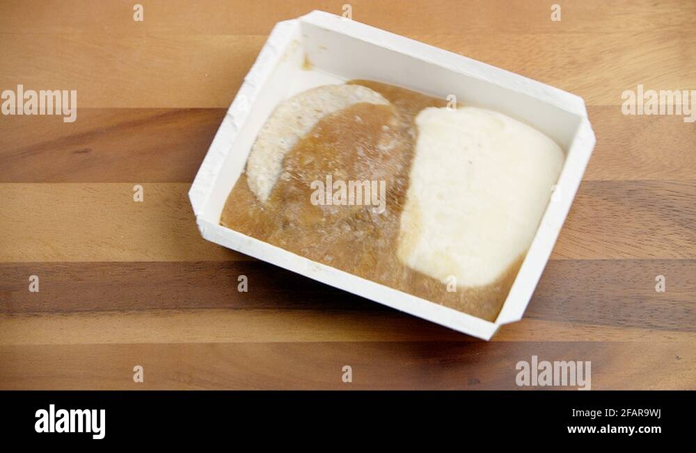 Packed frozen meal food box being thrown on table, and being grabbed ...