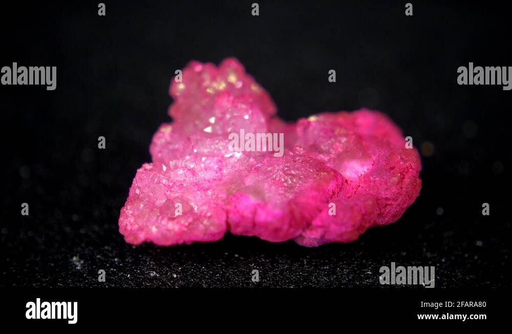 Seamlessly rotating a hearth shaped pink ore in front of black ...