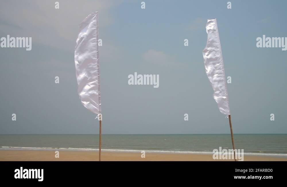 White beach flags flapping in the wind, empty tropical beach scene ...