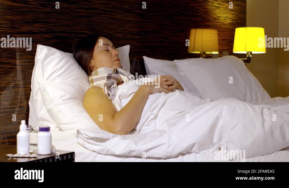 a woman with a fever is lying in bed at home. viral respiratory disease ...
