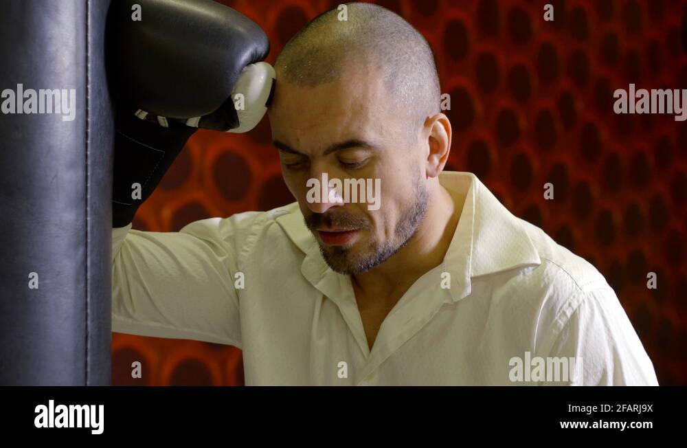 Bald boxer posing in a gym by punching bag, brutal man with beard in ...