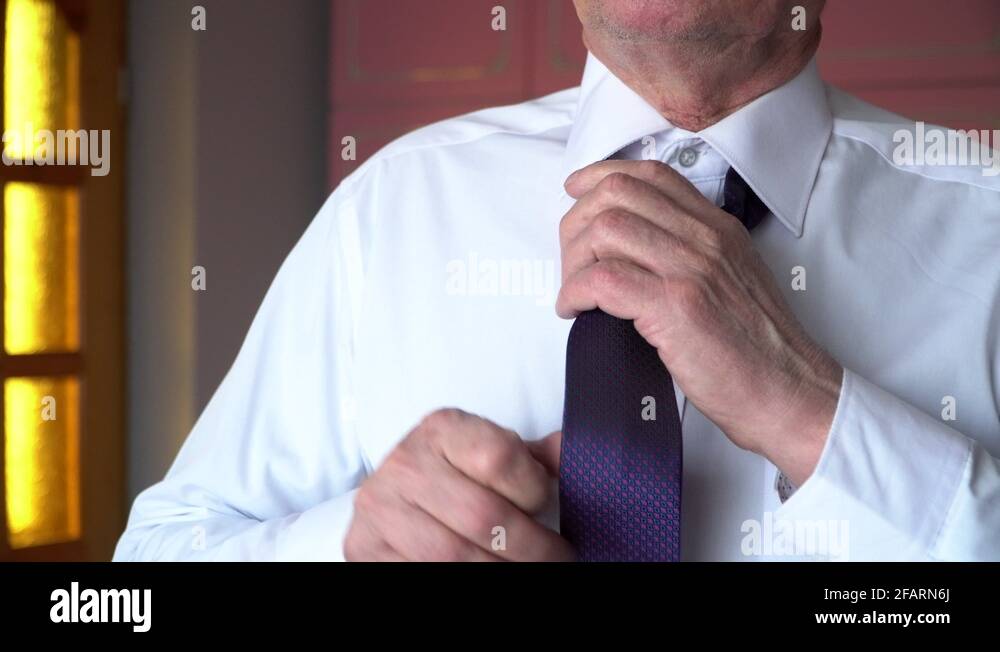 Retired old man preparing for work with fixing and arranging his formal ...