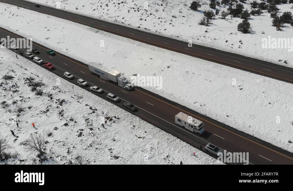 Vehicles pulling off the side of the freeway while people play in the ...