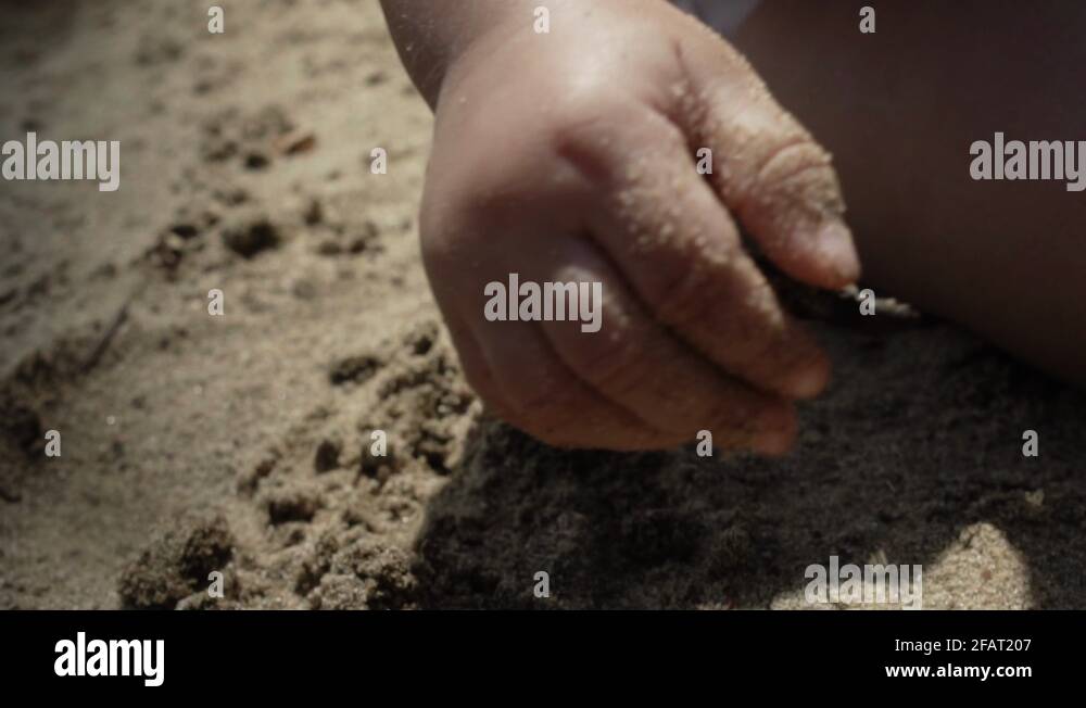 Baby hand grabbing a stone on a beach resort Stock Video Footage - Alamy