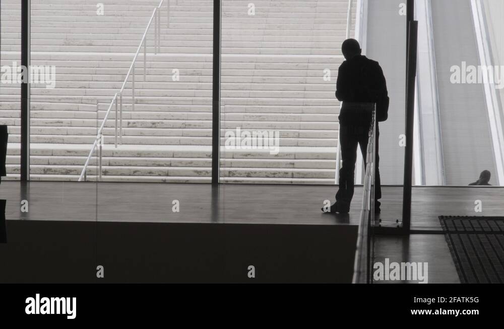 lonely man at the smartphone in a modern location of architecture and ...