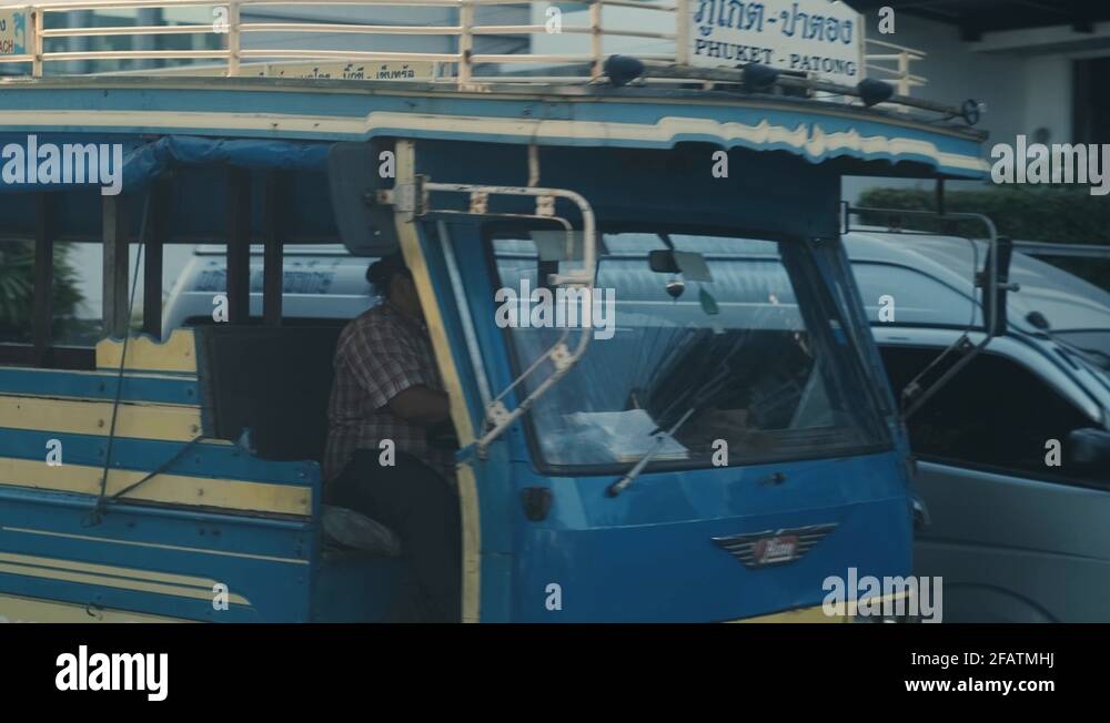 Bus driver in Phuket driving pass through street in Thailand during the ...