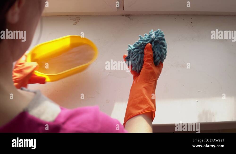 Woman wipes dust on the window sill Stock Video Footage - Alamy