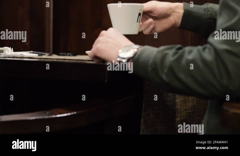 Man drinking coffee in restaurant, only hands and arms visible Stock ...
