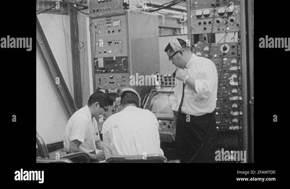 1960s: UNITED STATES: scientists at command center. Rocket launches ...