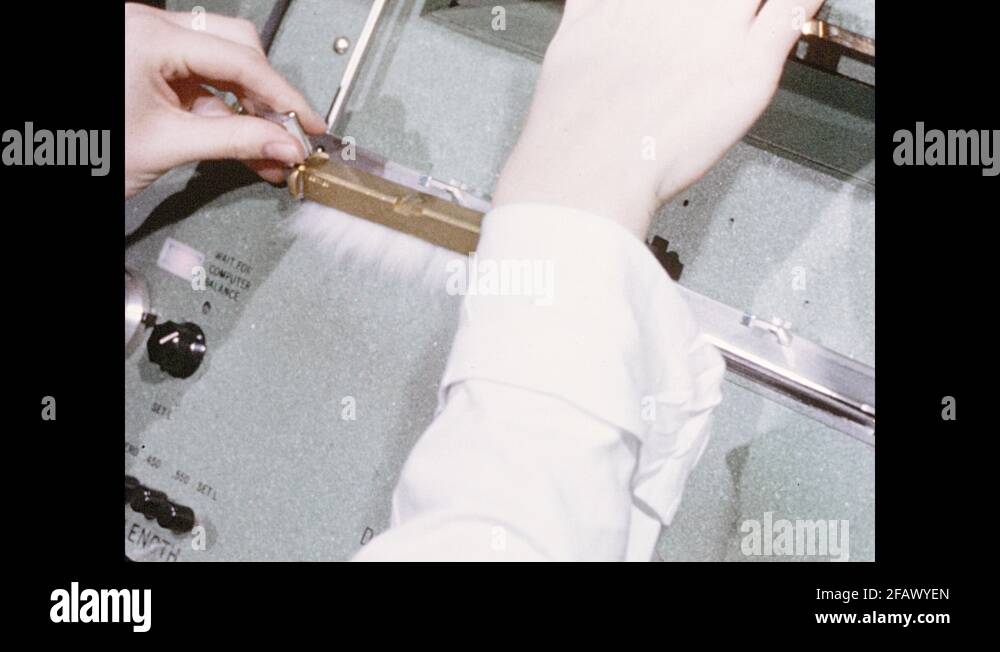 1960s: Woman lifts piece of machine and places metal piece on frame ...