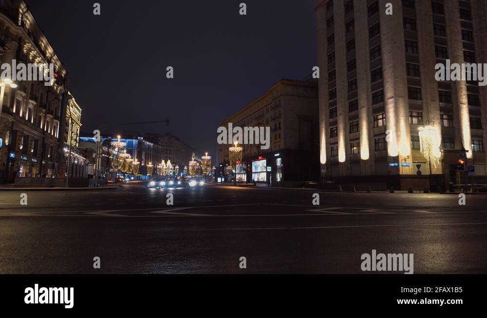Crossroads of night city. Majestic architecture, cars drive from left ...