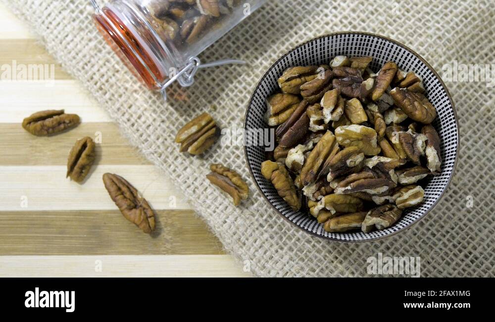Panning shot across table laid out with bowl full of pecans & walnuts ...