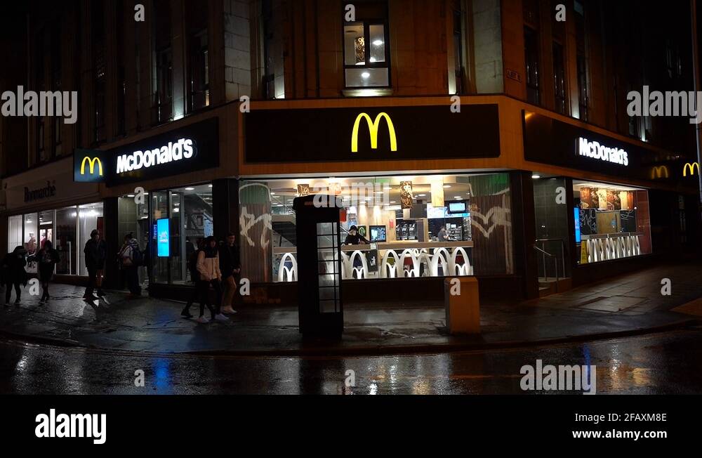 Customers entering and leaving fast food chain McDonalds in the high ...