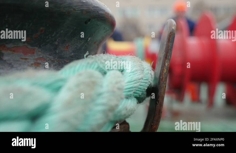 Knitted plastic rope turning around a metallic sheave outdoors in ...