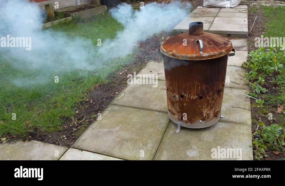 Refuse garden waste smoking & burning in steel dustbin incinerator in ...