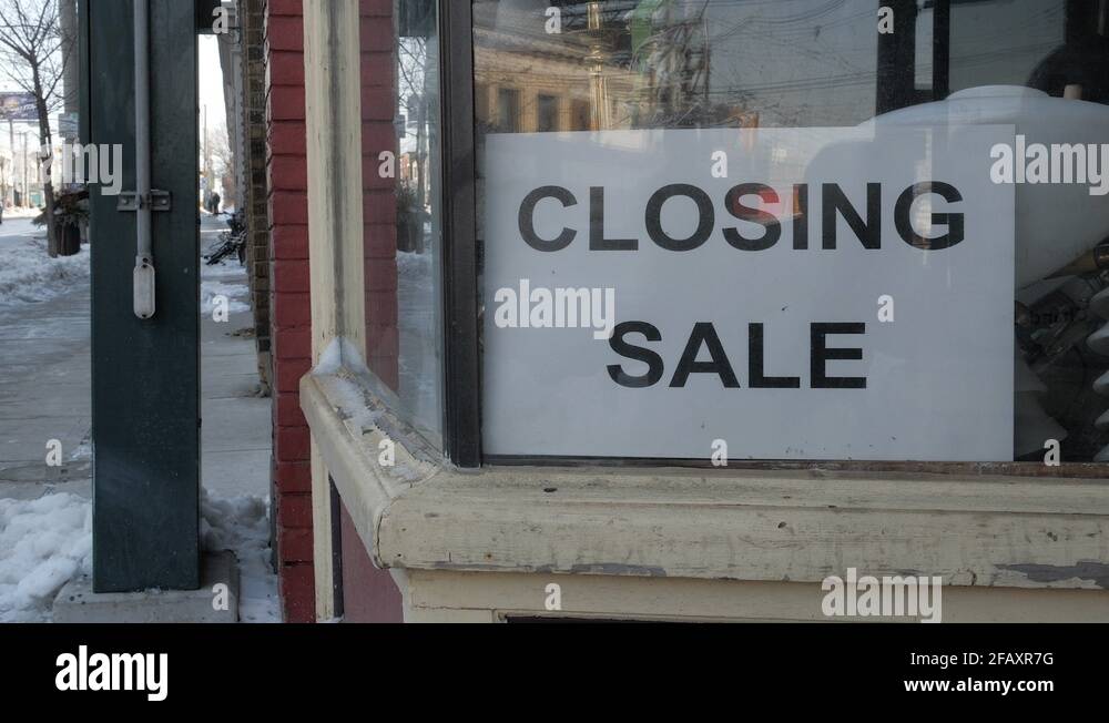 Close up of a closing sale sign in the window of an old store which is ...
