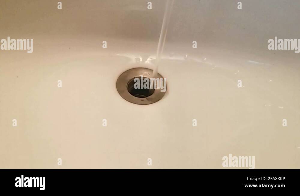 Running water falling, virtually unobstructed, into drain opening in ...