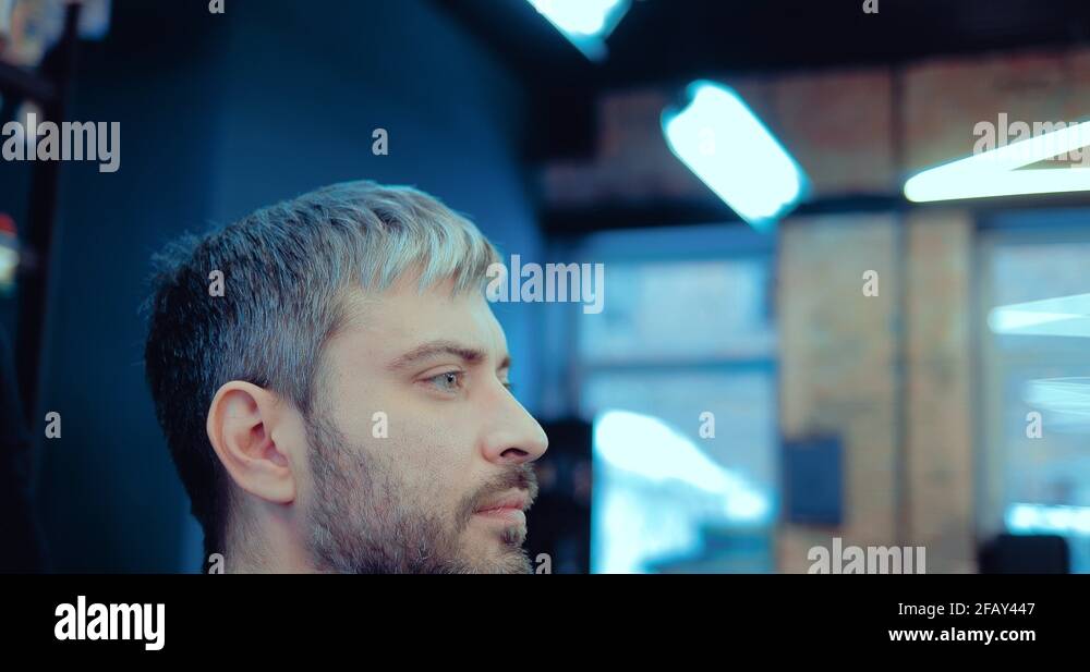 Hairdresser fixes the collar to the client around his neck before ...
