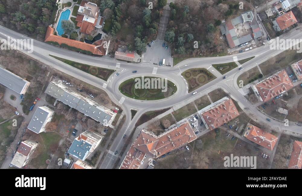 Drone lock down footage of an ellipse-shaped green roundabout while ...