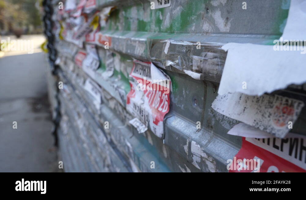 Torn advertisement tear off posters with text in Russian on a metal ...