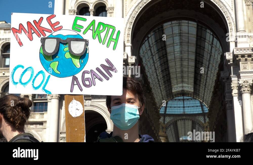 Boy picketing with picket sign against pollution, activist Duomo, Milan ...
