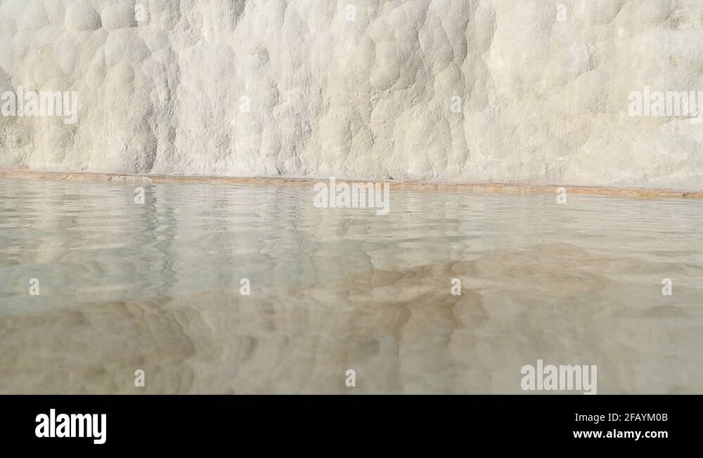 Beautiful spring water at Turkish Pamukkale reflect white travertine ...